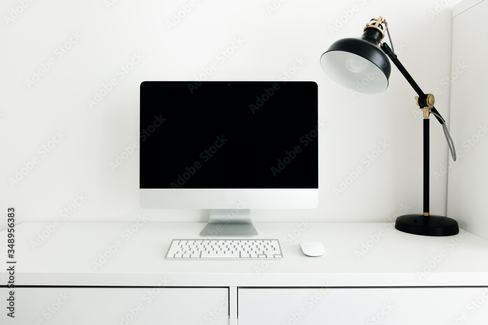 White desktop with black monitor and desk lamp. Workplace concept. Mock ...