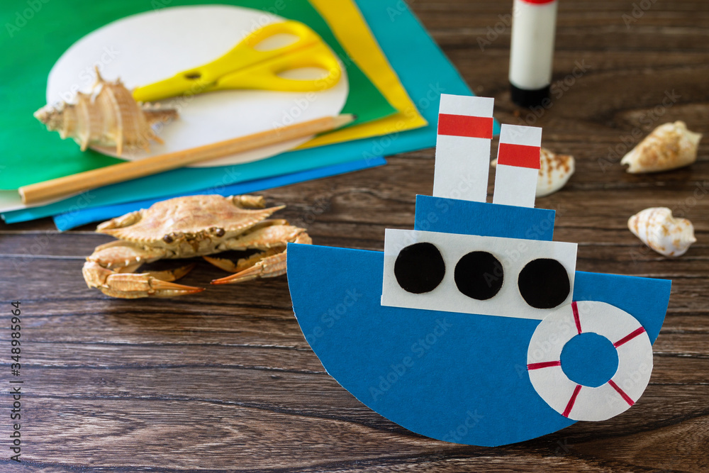 Gift paper boat for father's day on a wooden table. Children's art ...