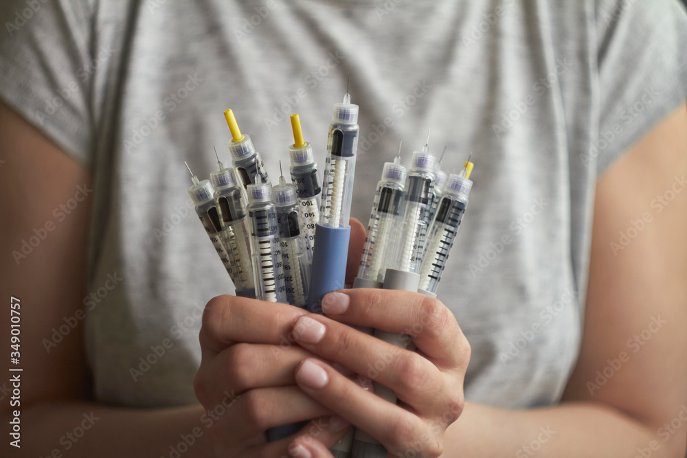 Diabetes insulin dependent concept, hands with syringes pen injectors ...