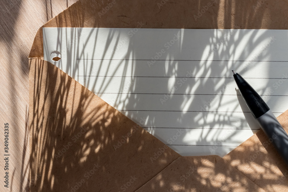 Lined sheet of paper (empty space for text) in craft envelope lies on ...