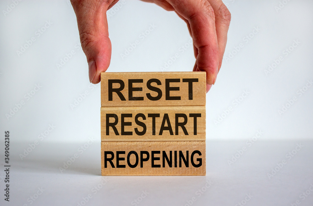 Male hand placing a blocks with word 'reset' on top of a blocks tower ...