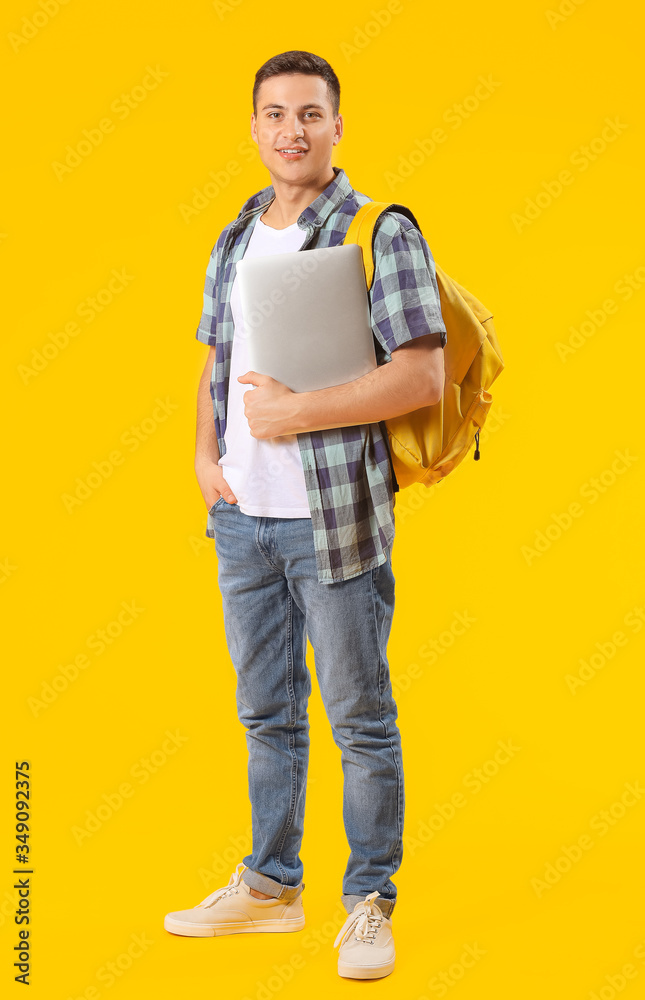 Male student with laptop on color background Stock Photo | Adobe Stock