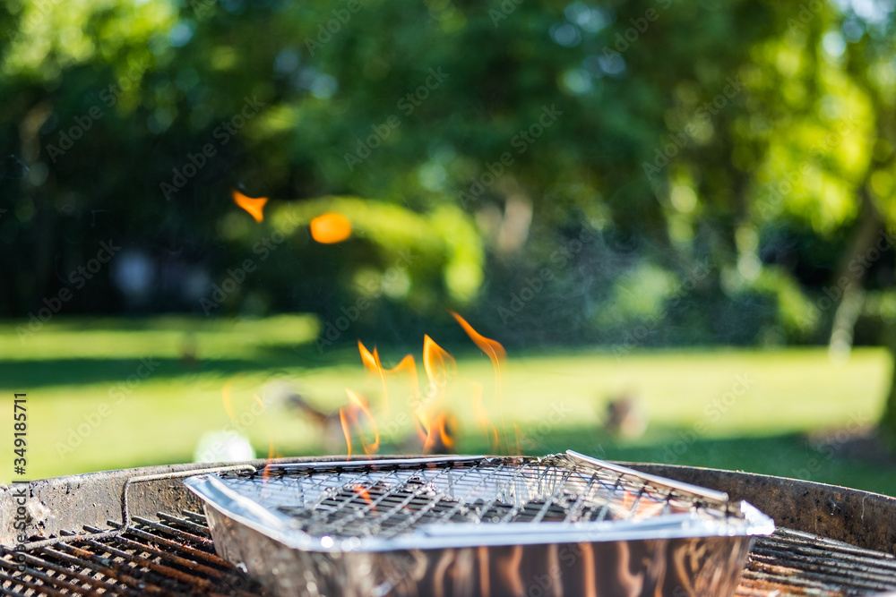 Shallow focus of a camping bbq seen in a full size bbq. Flames can be ...