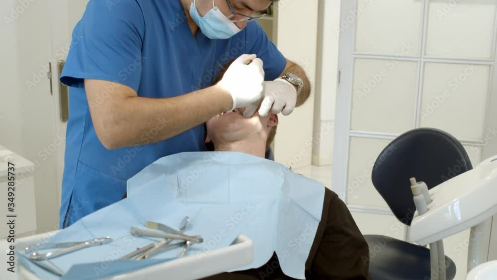 Dental clinic. Doctor dentist treats teeth to the patient in the dental ...