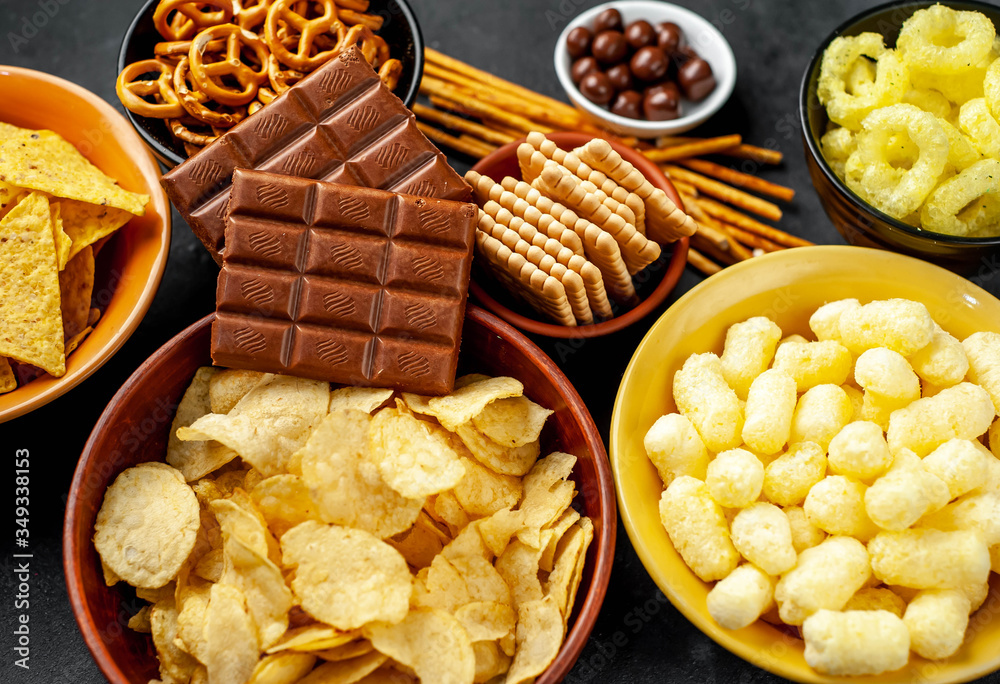 Unhealthy food. pretzels different chips, crackers, chicolad, cookies ...