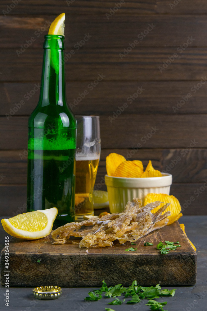 Silver Amber Fish with pepper with beer, lemon and potato chips on dark ...