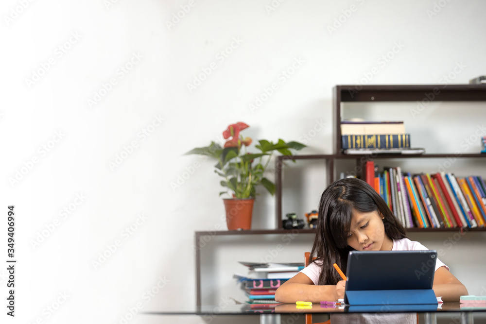 Mexican girl studying online with tablet at home concentrated writing ...