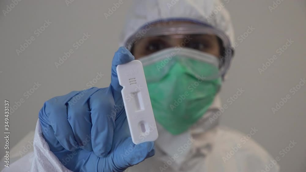 Doctor in hazmat suit shows rapid testing kit for coronavirus Covid-19 ...
