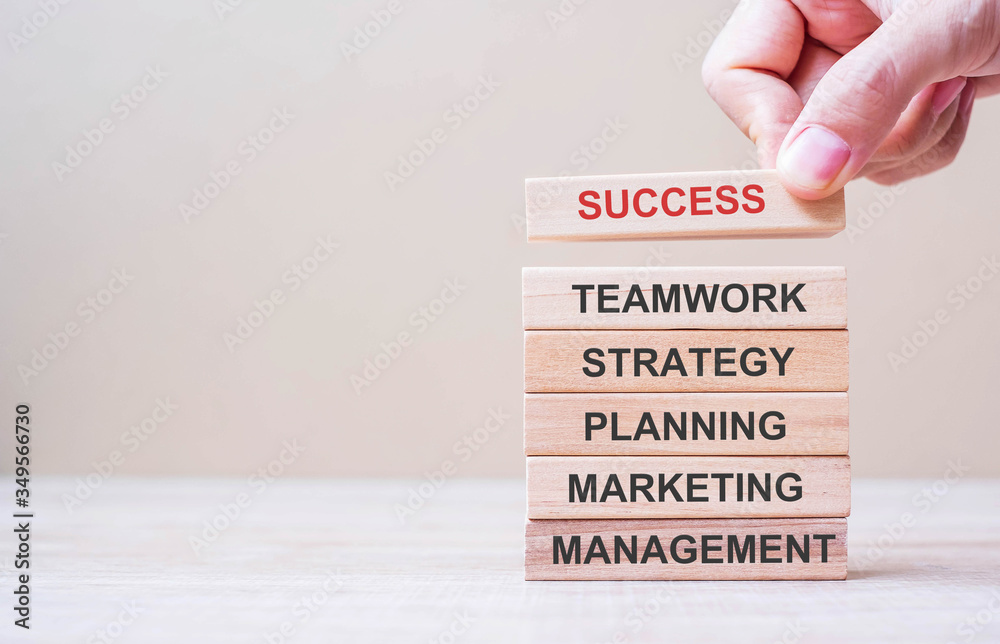 Businessman hand placing or pulling wooden block on the tower with text ...