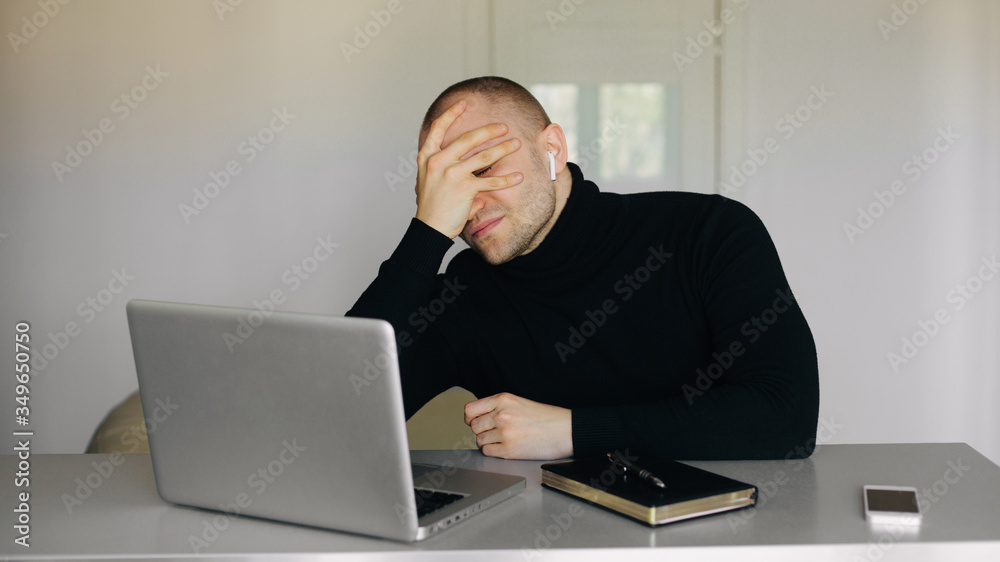Overworked tired frustrated young bald freelancer man is holding his ...