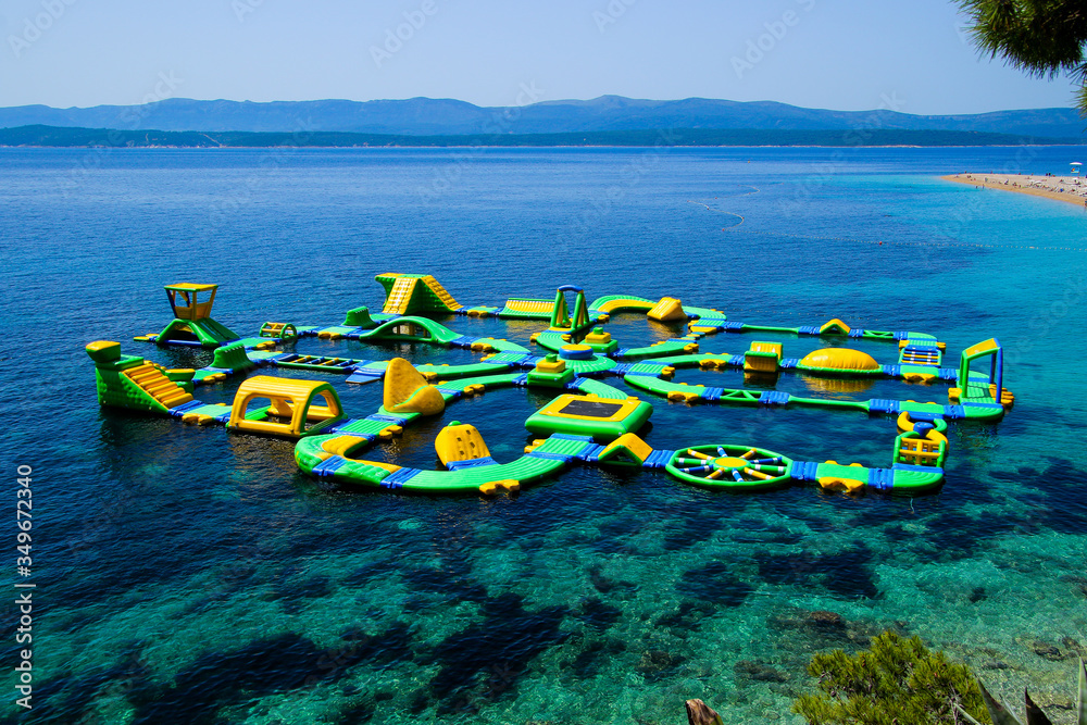 Floating inflatable playground with water slides, swings and ...
