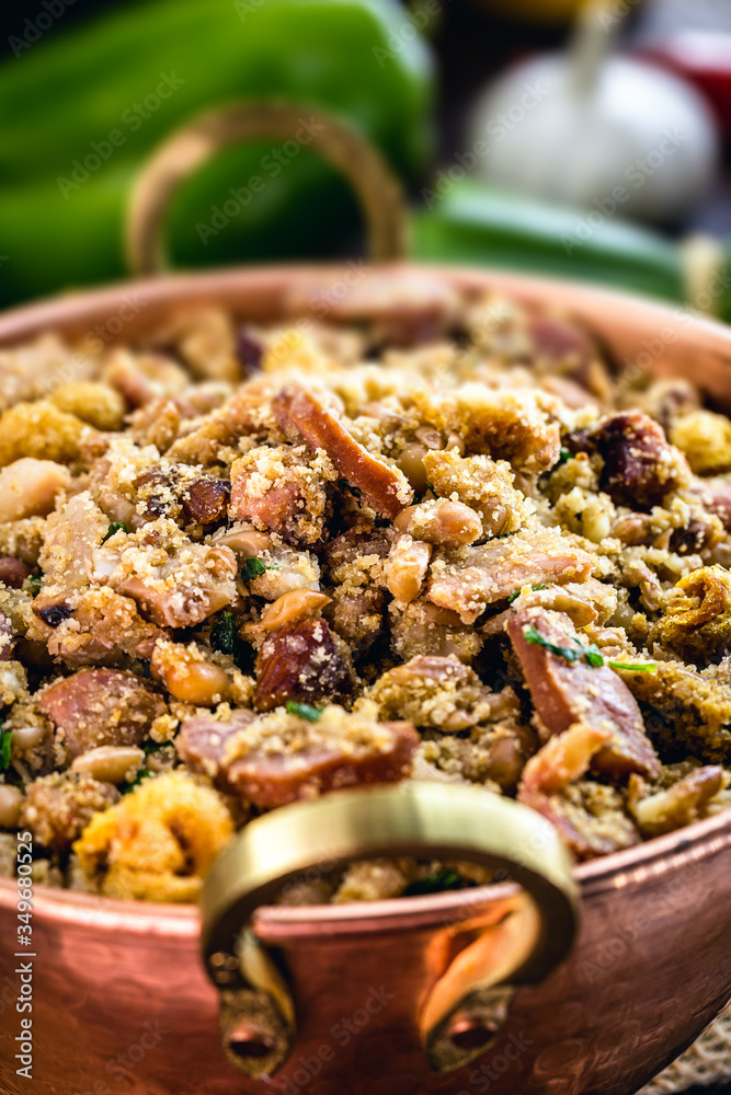 Feijão tropeiro, typical Brazilian food, in a copper pot, rustic ...
