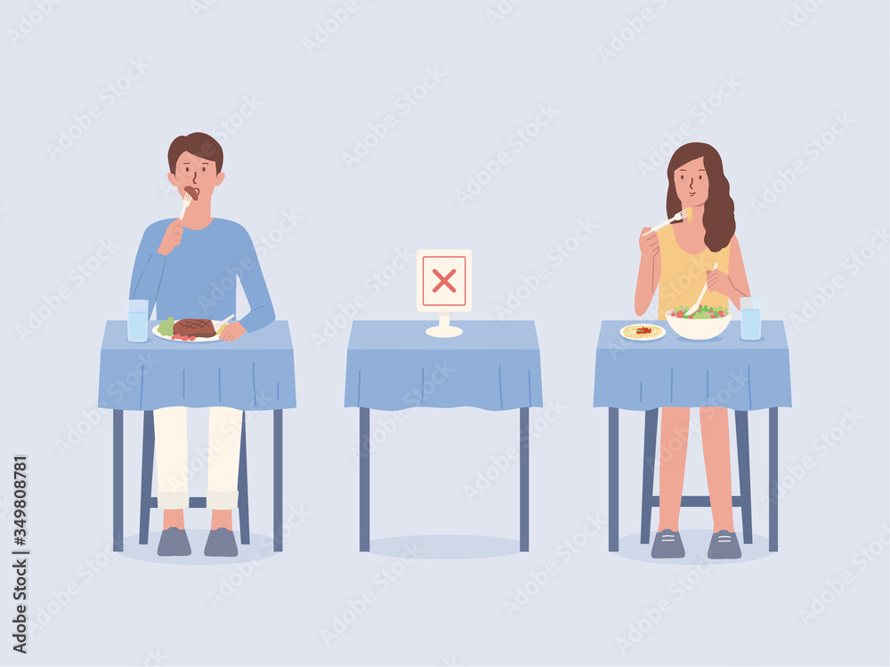 Man and Women doing social distancing while eating food alone at tables ...
