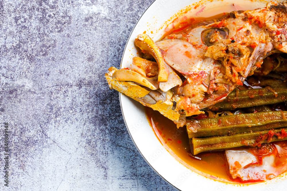 A flatlay picture of red snapper head in "asam pedas" on copy space ...