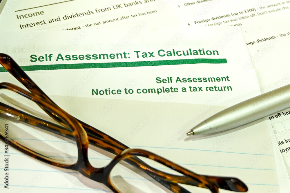 Close up view of a self assessment tax return form with a pen, a pair ...
