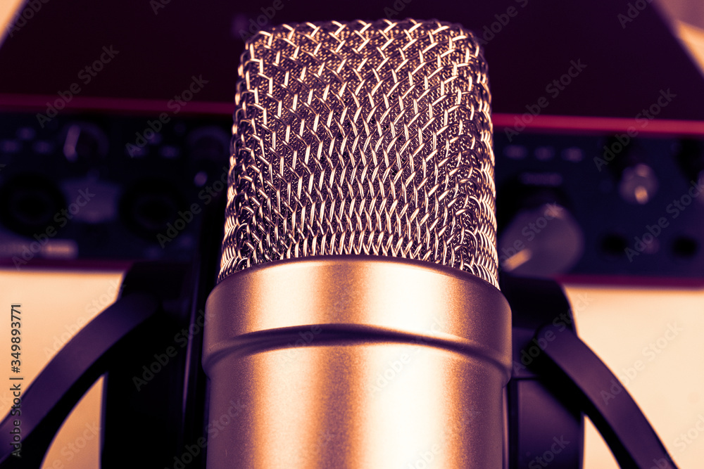 Condenser microphone closeup with sound interface background, red and ...