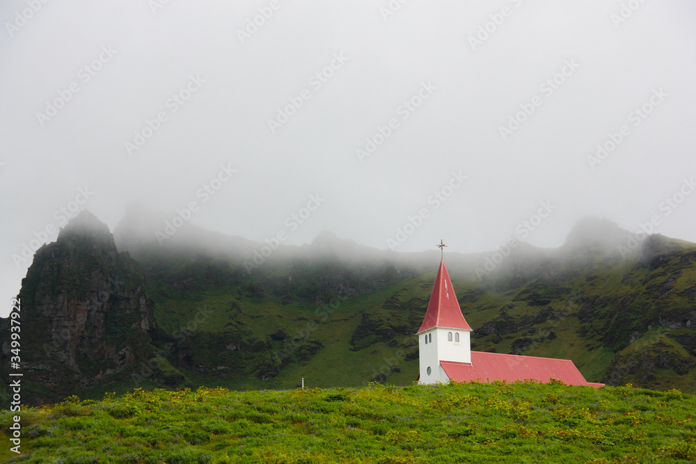 a small church in the town of Vik is located on the top of a hill, the ...