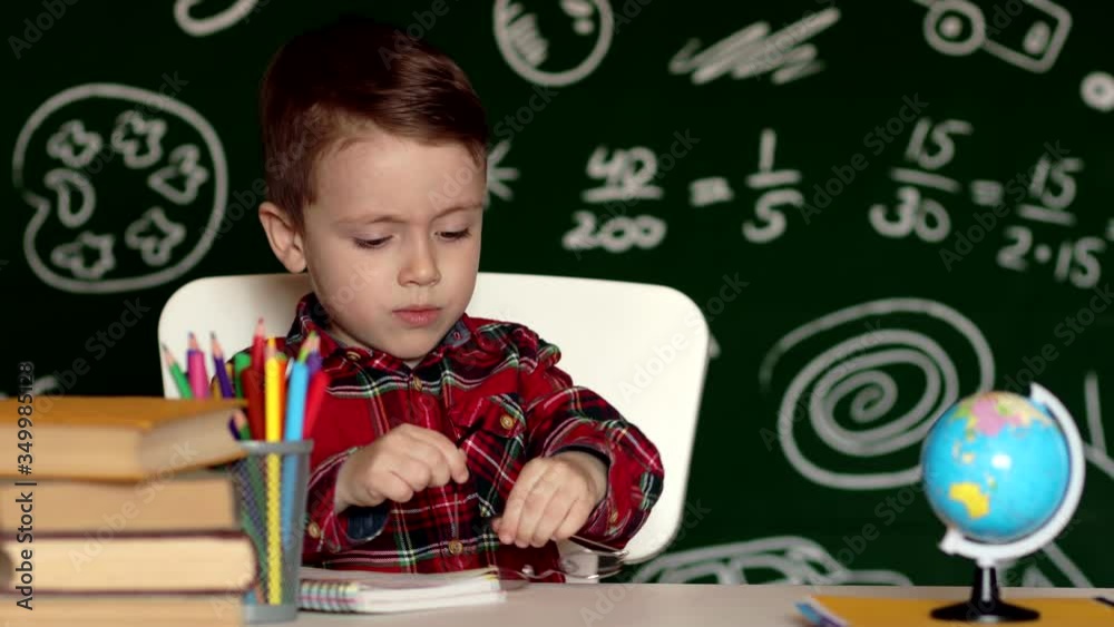 Cute child boy doing homework. Clever kid drawing at desk. Schoolboy ...