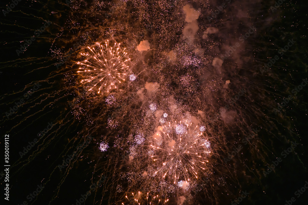 Red and orange fireworks with smoke over the black sky. Low key ...
