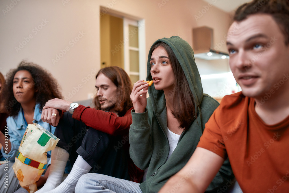 Together. Group of teenagers eating snacks and talking while having fun ...