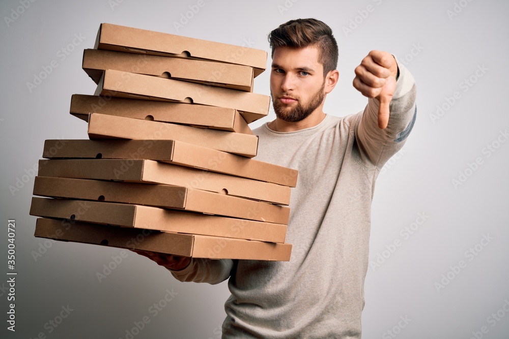 Young blond man with beard and blue eyes holding cardboards of pizza ...