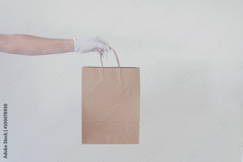 Hand with gloves holding eco paper bag, take away food, home delivery ...