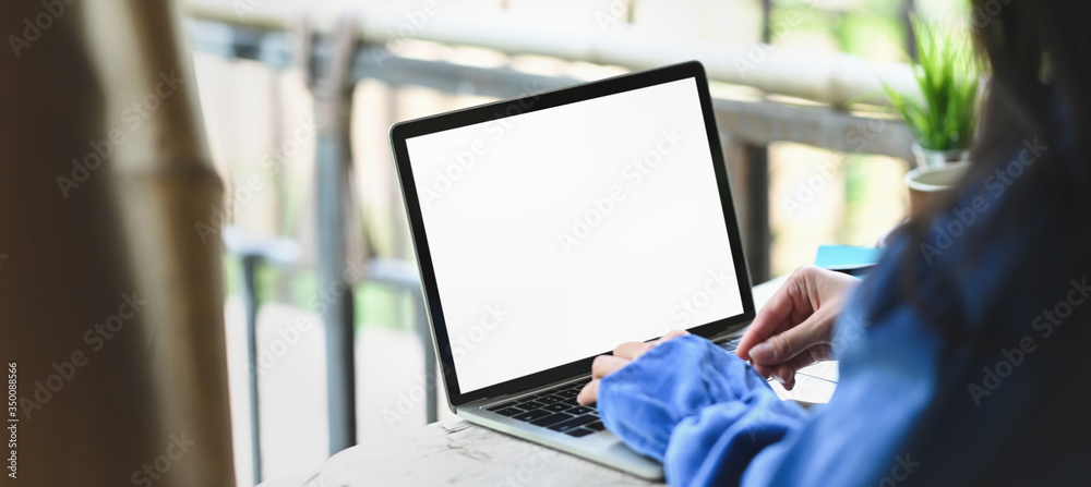 Cropped image of woman's hands typing on white blank screen computer ...