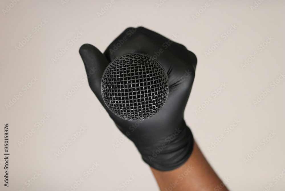 Hand holding dynamic microphone. first person view. wearing black vinyl ...