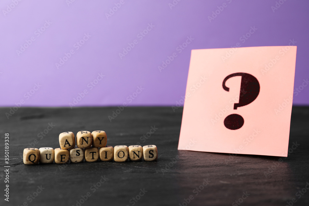 Phrase Any Questions made of wooden cubes and note with punctuation ...