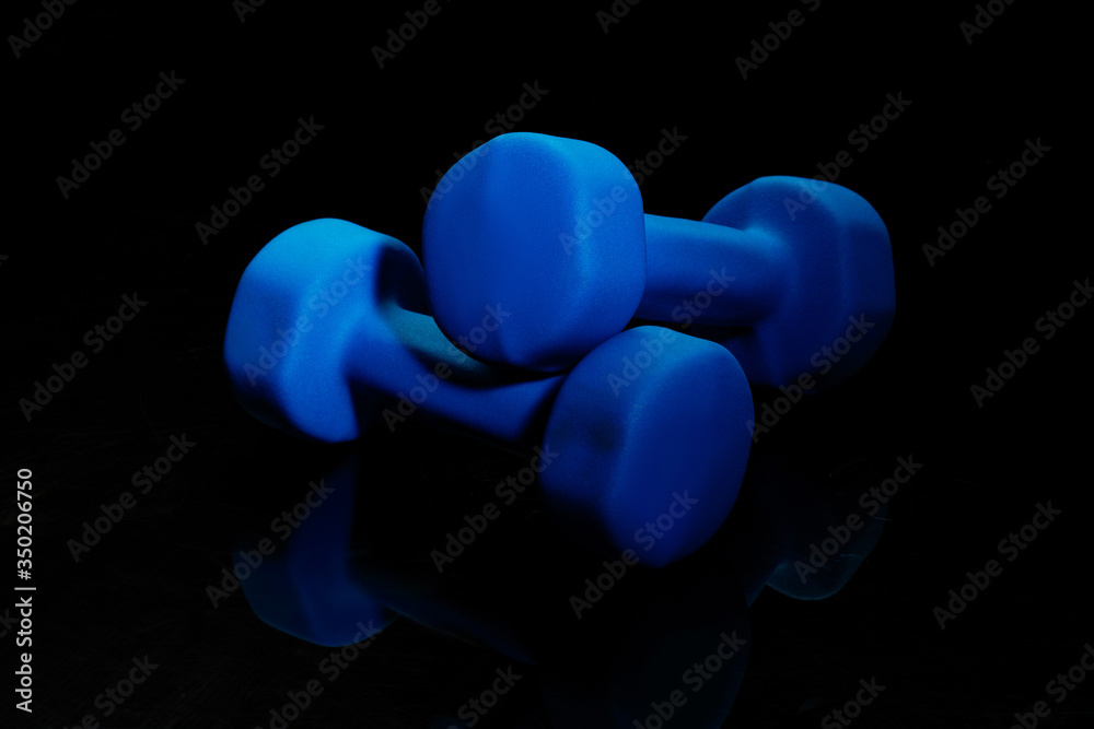 Blue gym weights. Professional sport equipment isolated on black studio ...