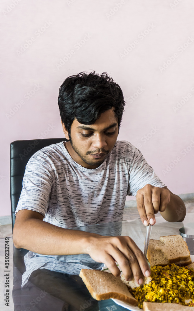 Man eating egg Bhurji. Egg bhurji with bread. Egg bhurji is a dish ...