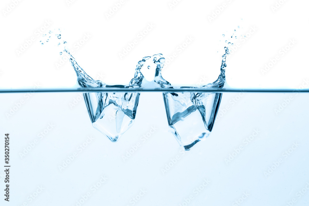 Ice cubes splash in water isolated on white. Two ice cubes dropped into ...