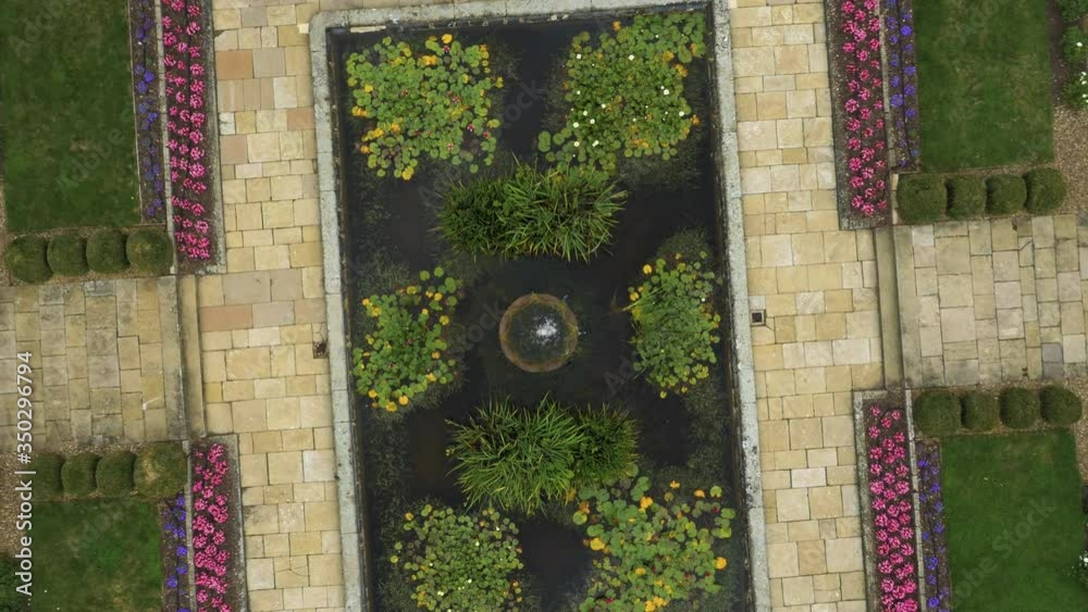 Birds eye view of symmetrical gardens with paved walkways and colourful ...