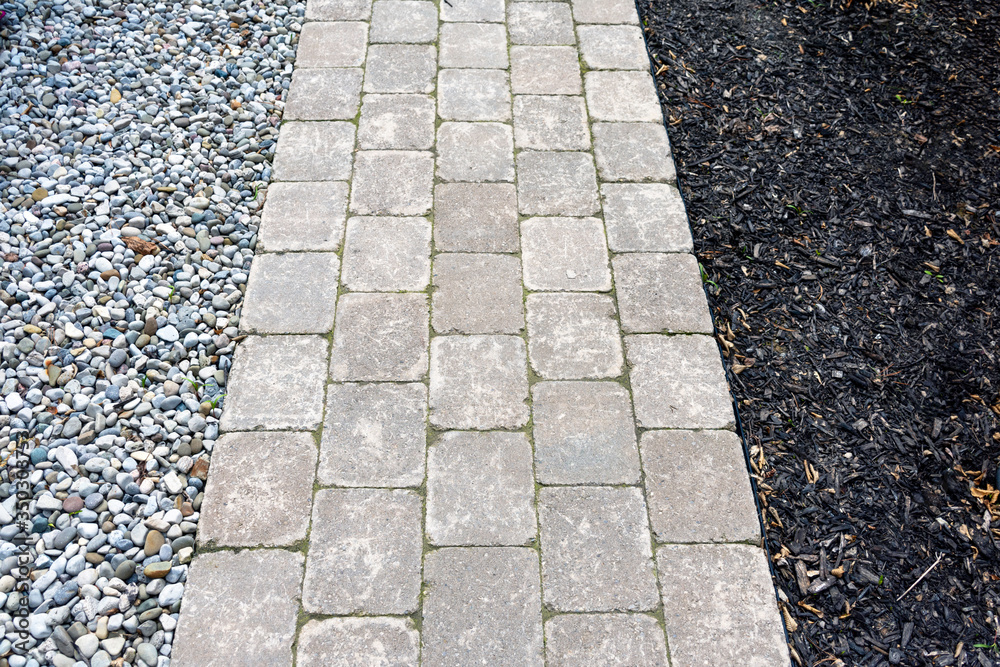 Tumbled paver walkway with wood chip and pea gravel mulches create a ...