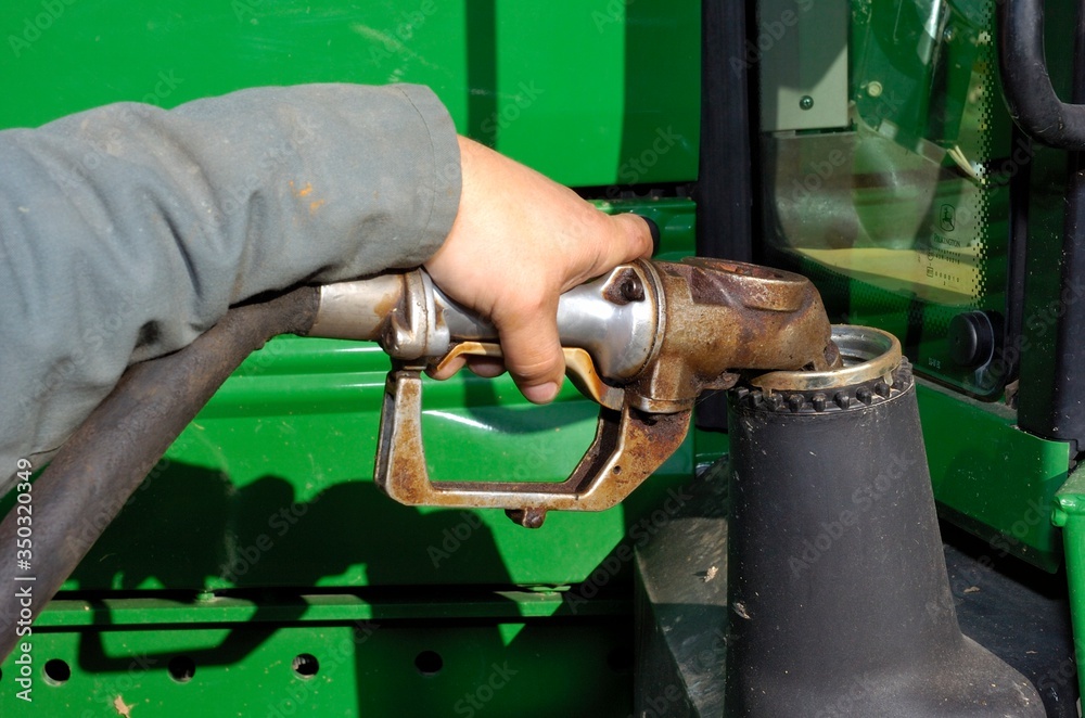 Agriculteur effectuant le plein de gas-oil GNR pour son tracteur. Main ...
