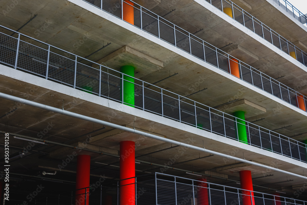 Building with concrete floors and colored support columns. Multi-level ...