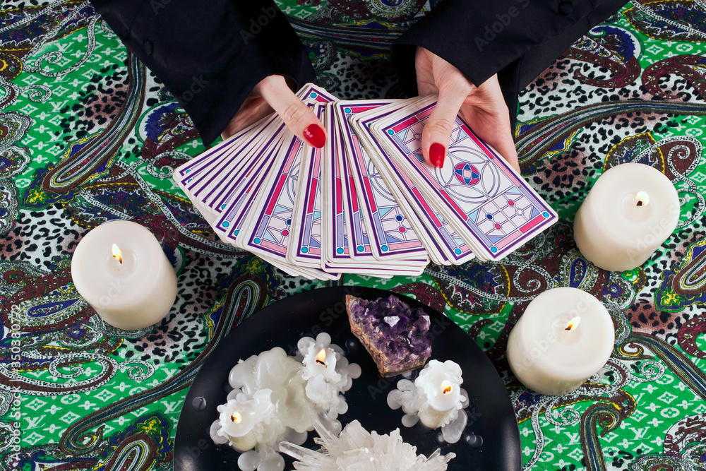 Fortune teller woman predicting future from cards on a table with ...