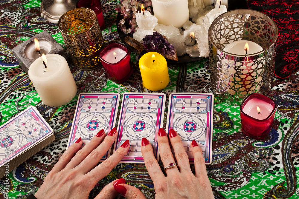 Fortune teller woman predicting future from cards on a table with ...