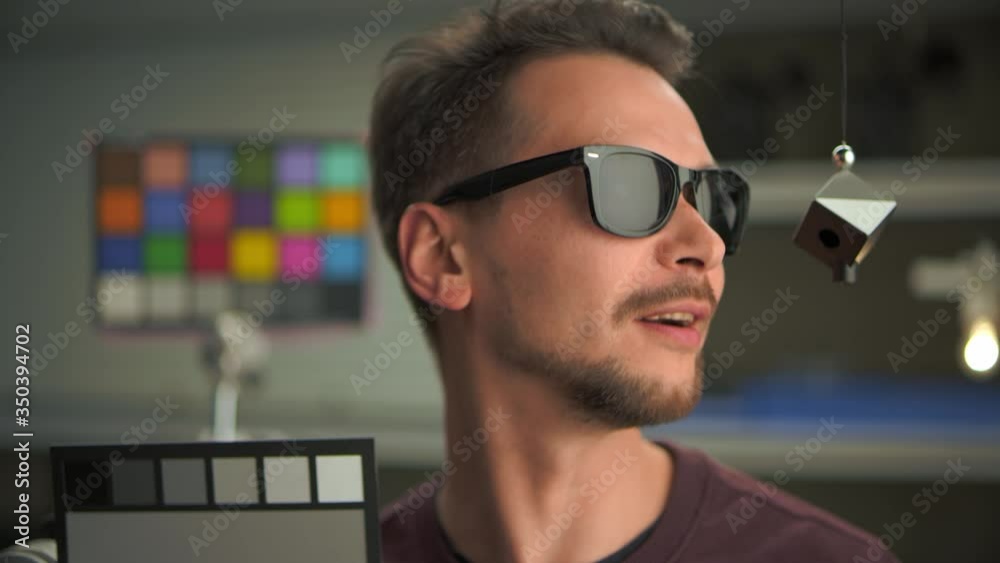 Video balanced by ColorChecker. Man testing professional film camera ...