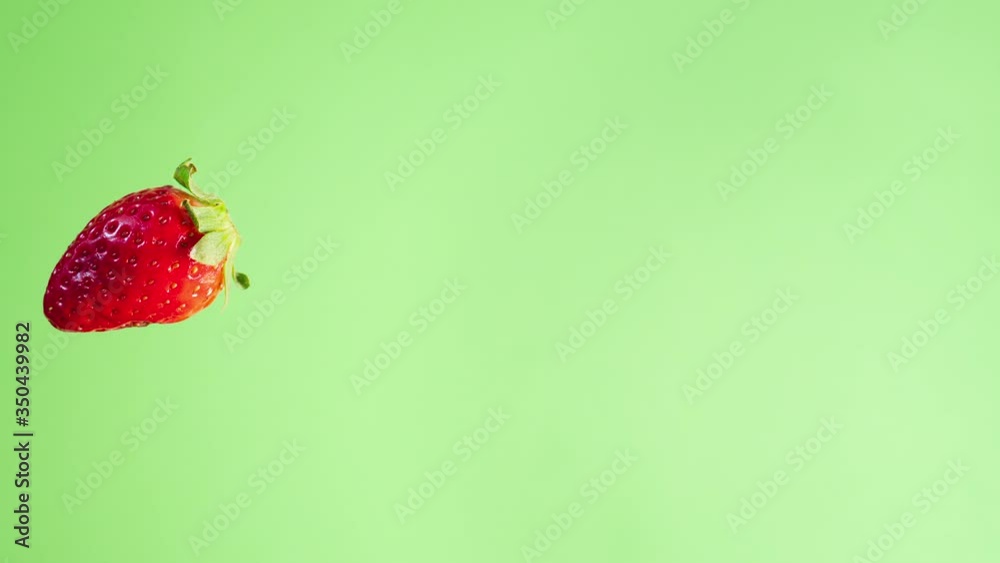 4K stop motion video of a fresh strawberry passing through the frame ...