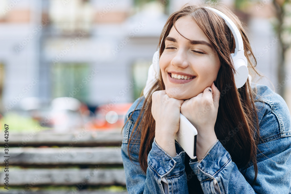 Young, smiling woman listening music with headphones. Girl listening ...