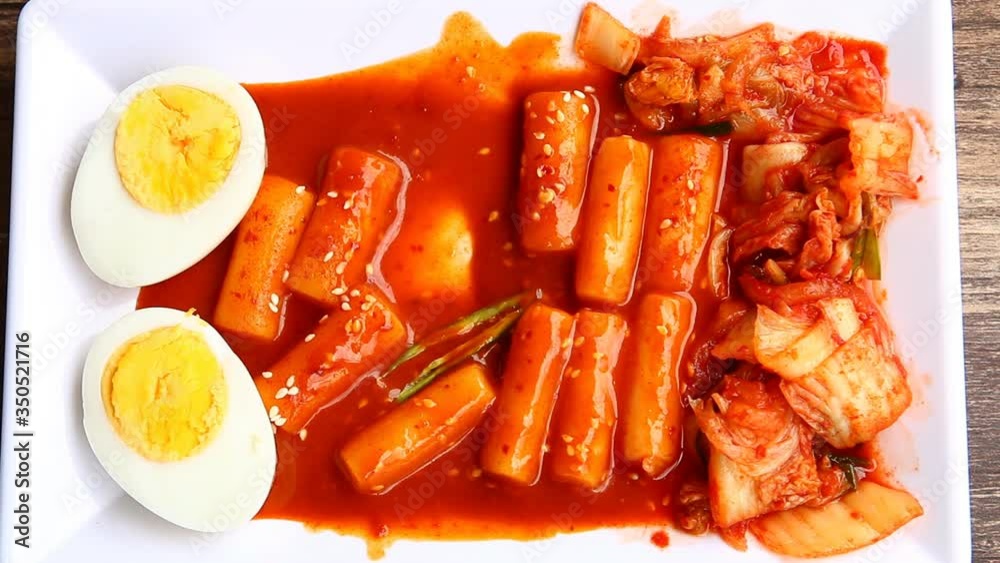 Man eating tteokbokki or spicy rice cake and kimchi, Korean famous food ...