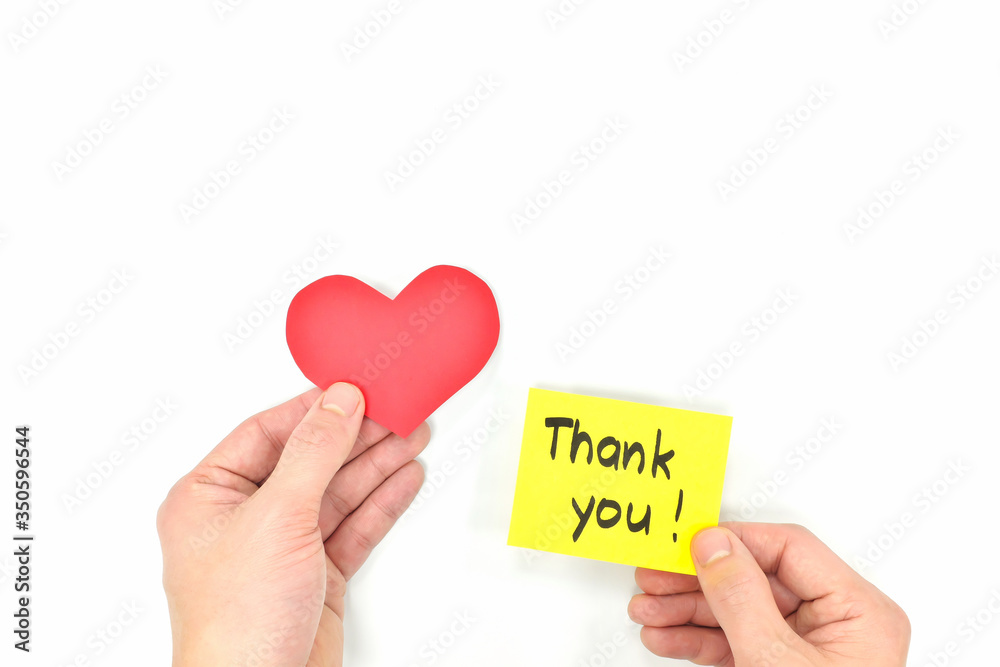 Male hands holding a bright yellow thank you card note and a red heart ...