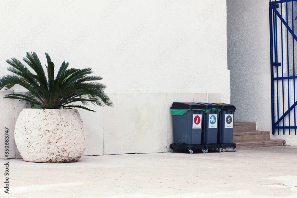 Three dumpsters with waste classification icons and small decorative ...