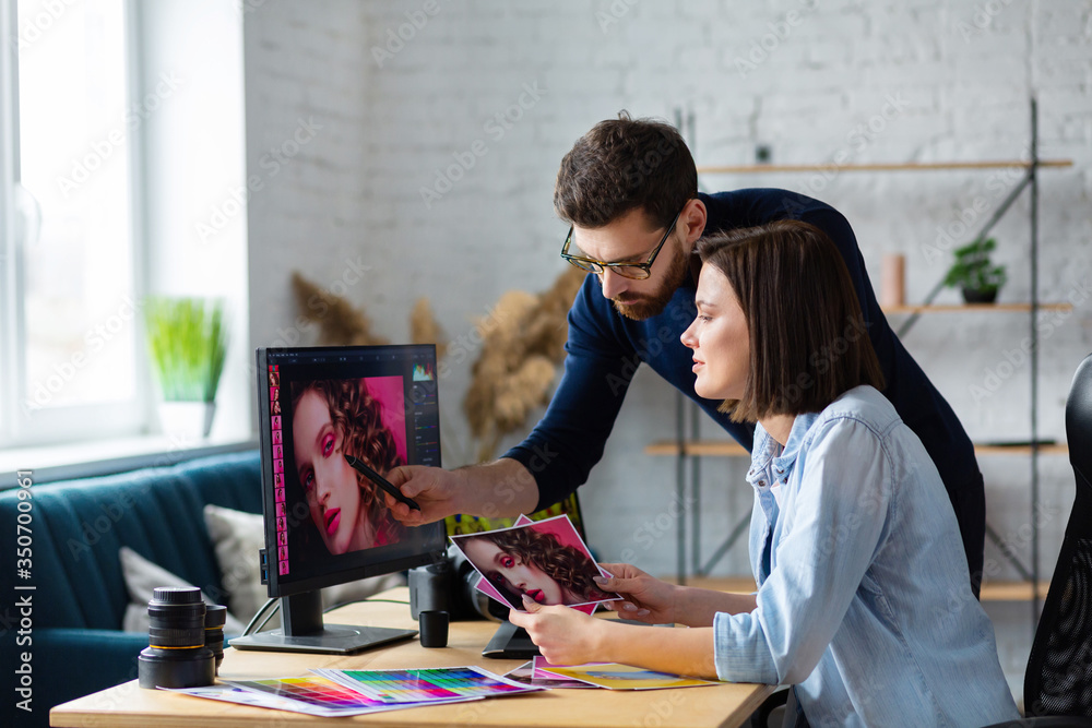 Photographer and graphic designer working in office with laptop ...