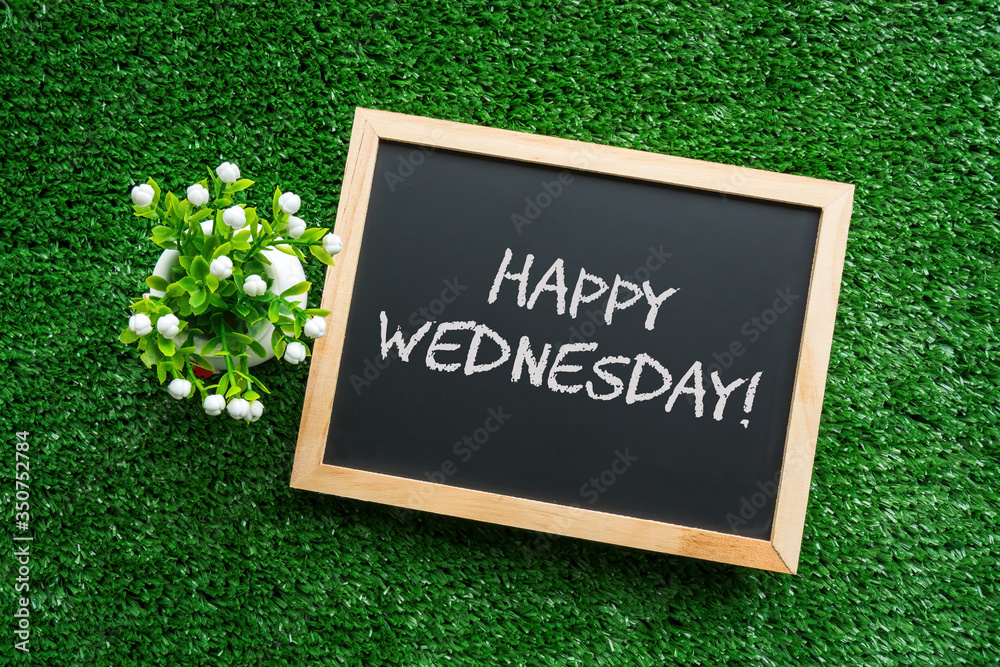 HAPPY WEDNESDAY text in white chalk handwriting on a blackboard with ...