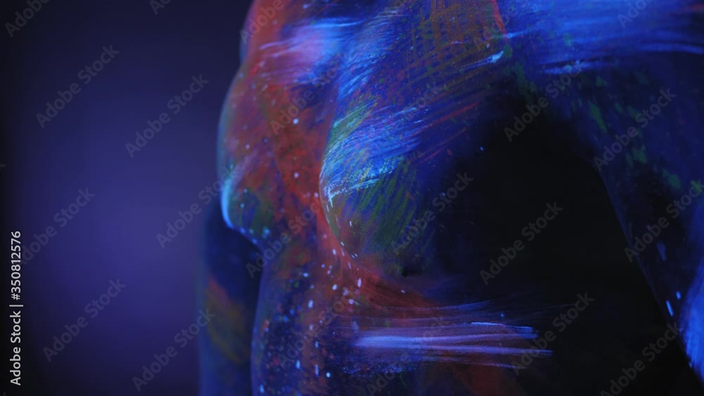 Close-up of the naked chest of a muscular man with ultraviolet drawings ...
