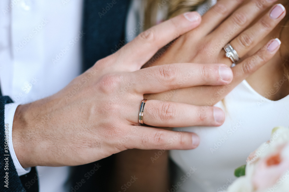 The joined hands of the bride and groom at a wedding. Wedding rings on ...