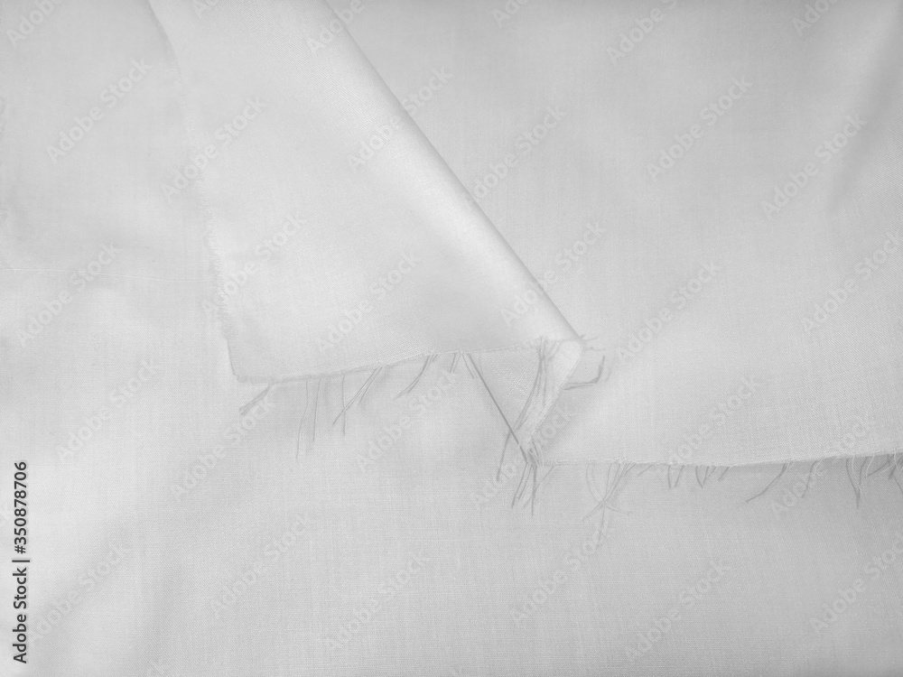 White natural rough fabric with a curved corner and a disheveled edge ...