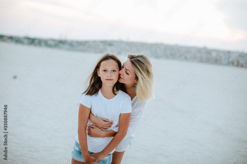 Young woman hugging girl on the white beach in the summer Stock Photo ...